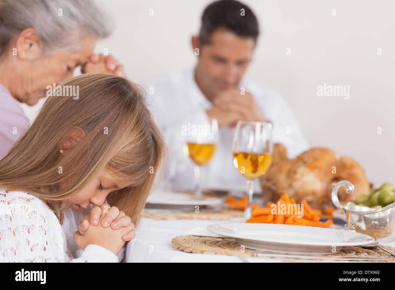 Little girl saying grace with family Stock Photo - Alamy