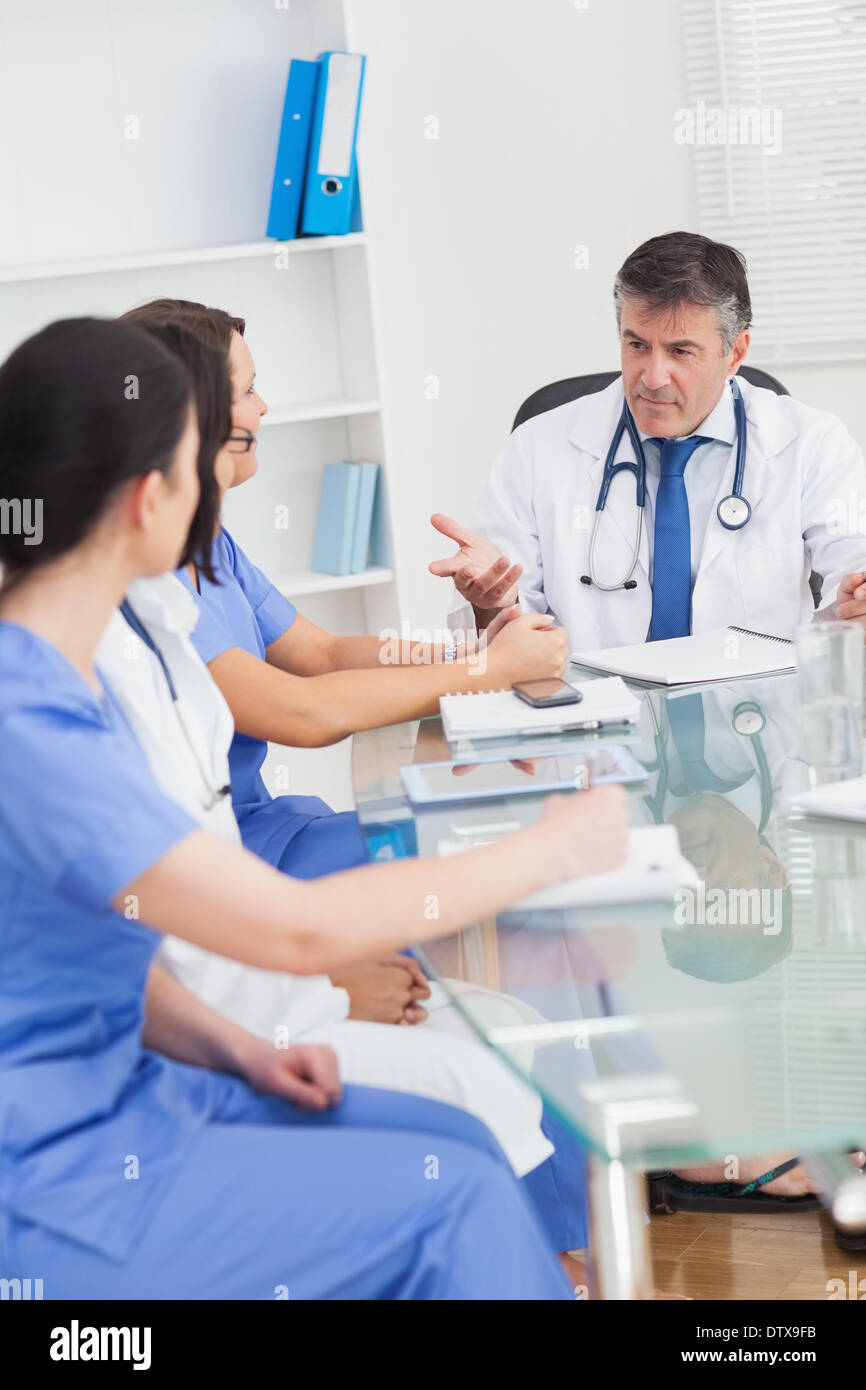 Meeting between a doctor and three nurses Stock Photo - Alamy