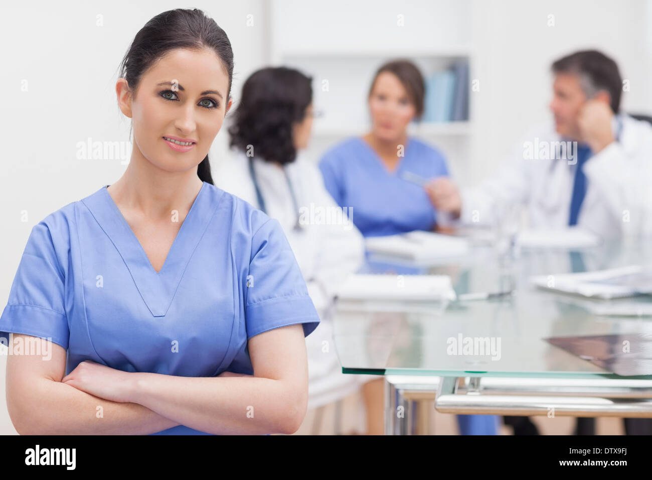 Nurse with arms crossed and her team Stock Photo - Alamy