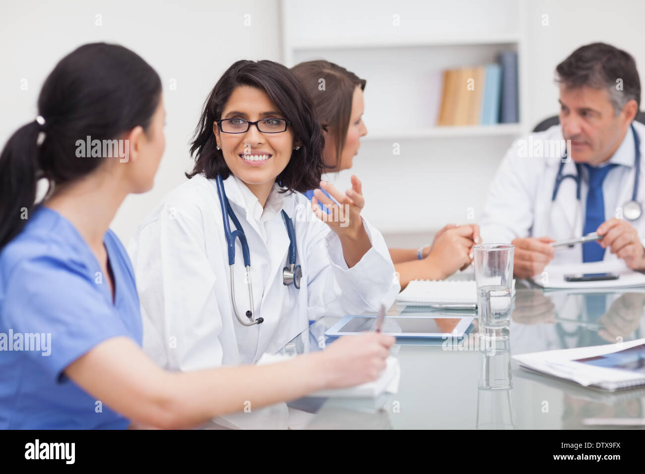 Two doctors speaking with two nurses Stock Photo - Alamy