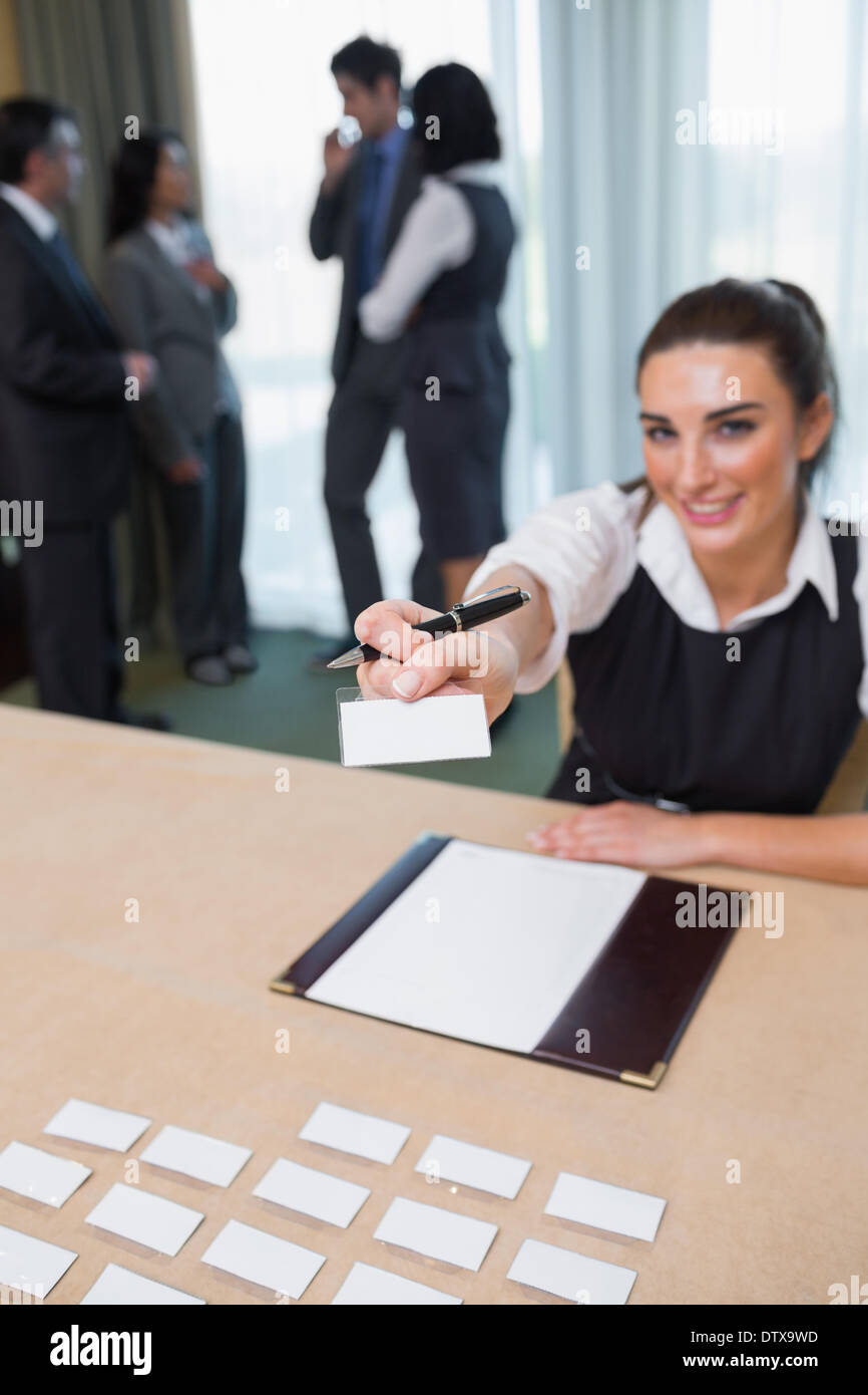 Woman handing you a name tag Stock Photo - Alamy