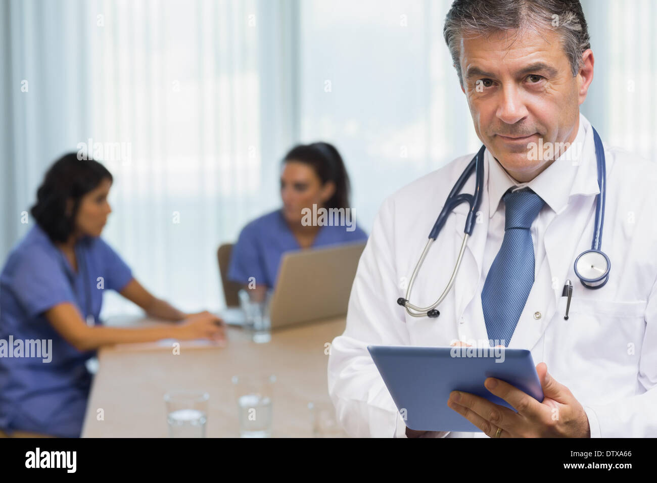 Smiling doctor with tablet Stock Photo - Alamy
