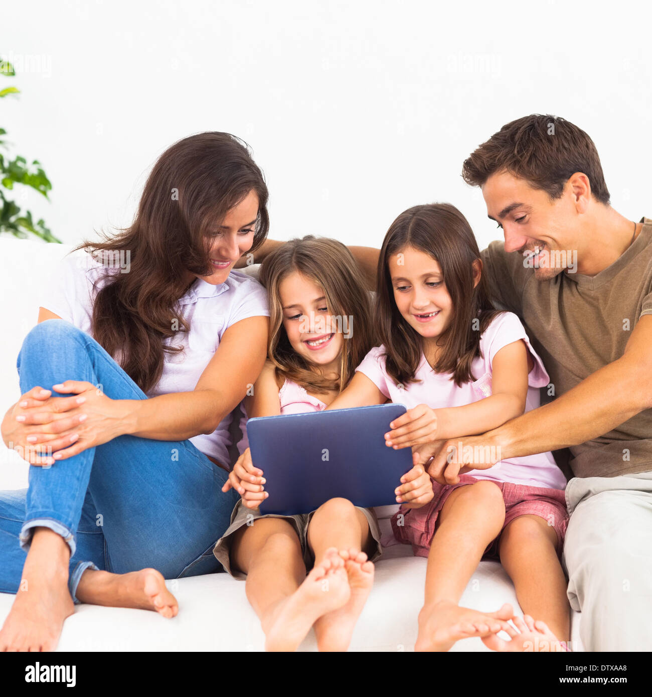 Pretty family using a digital tablet Stock Photo - Alamy