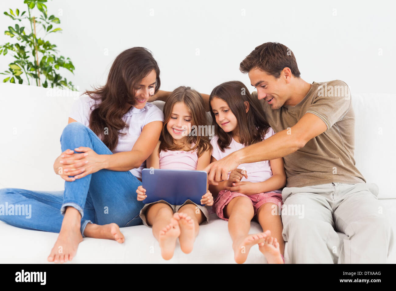 Smiling family using a digital tablet Stock Photo - Alamy