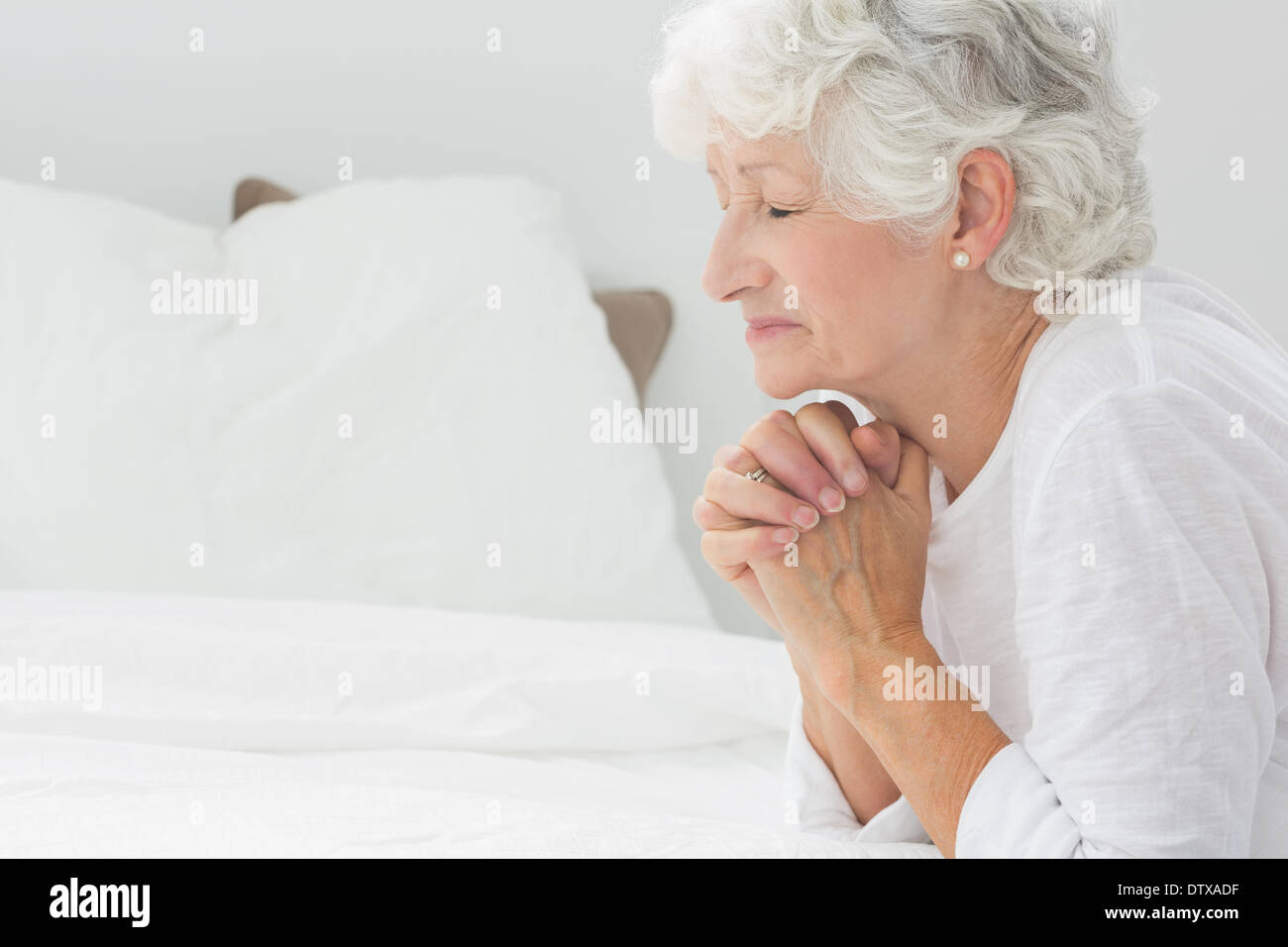 Old woman praying hi-res stock photography and images - Alamy