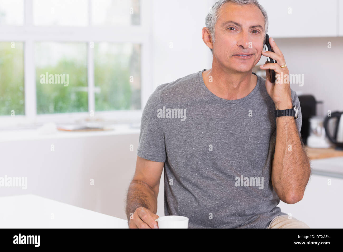 Man drinking while phoning Stock Photo - Alamy