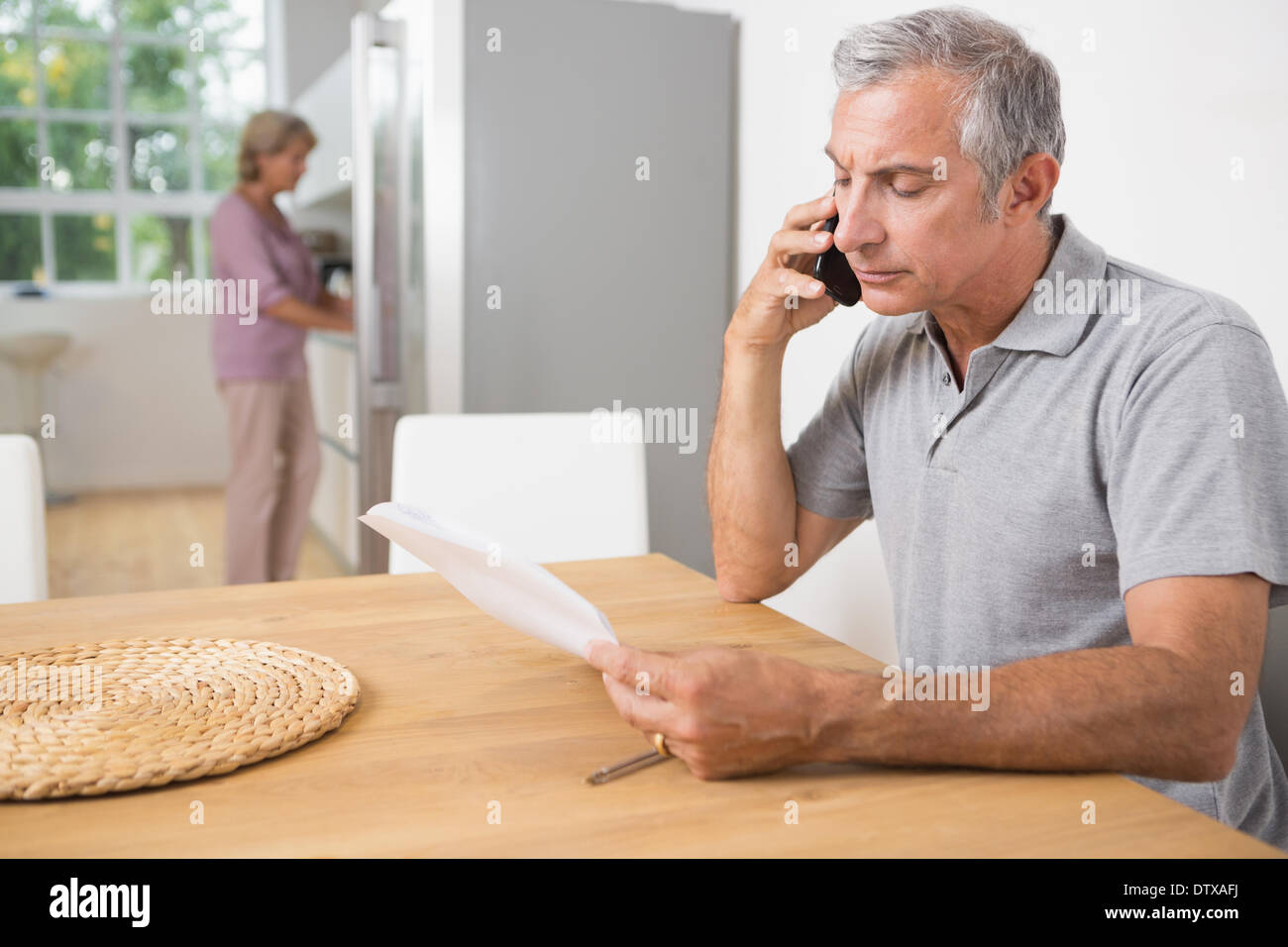 Man calling and reading a sheet of paper Stock Photo - Alamy