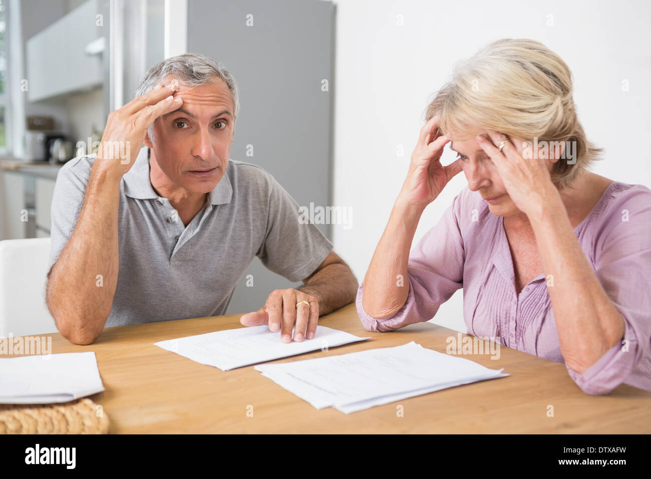 Concentrated couple reading documents together Stock Photo - Alamy