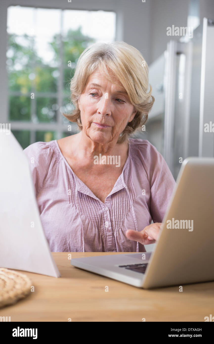 Focused mature woman sitting table hi-res stock photography and images ...