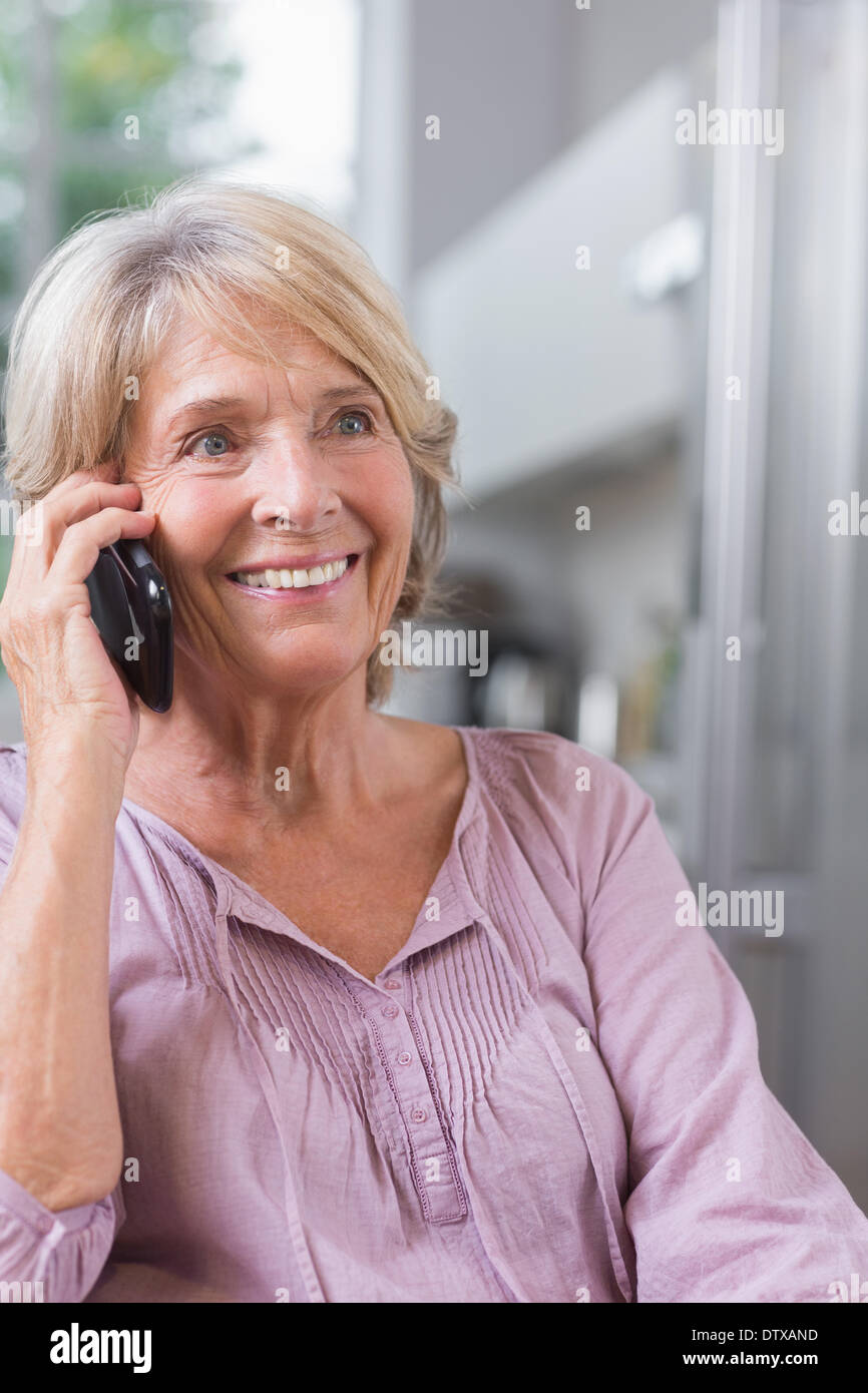 Smiling mature woman calling Stock Photo - Alamy