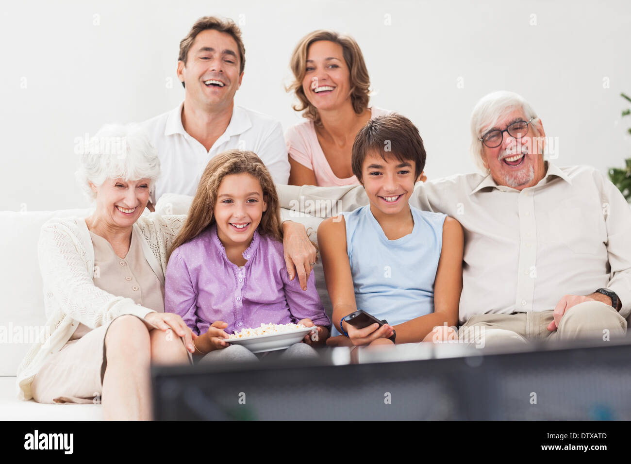 Extended family watching tv Stock Photo - Alamy