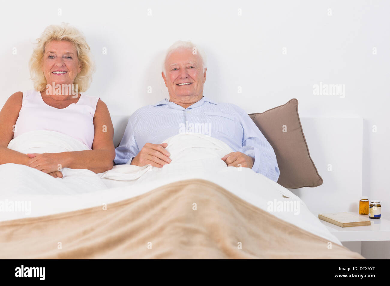 Old couple lying on the bed Stock Photo - Alamy