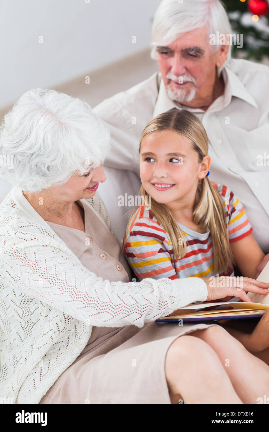 Grandparents with granddaughter reading Stock Photo - Alamy