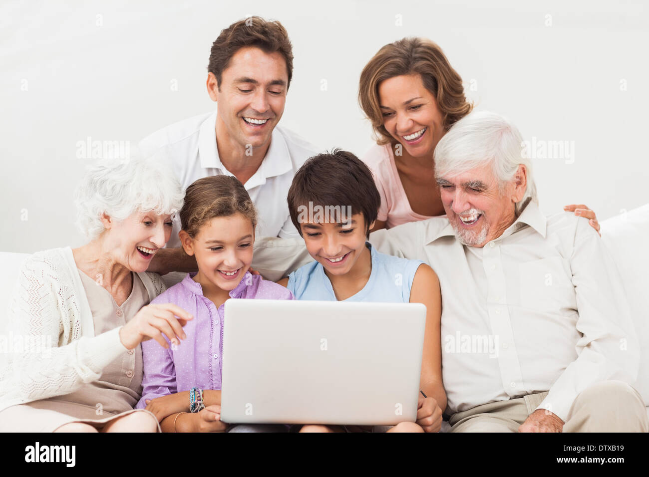 Extended family looking at laptop Stock Photo - Alamy