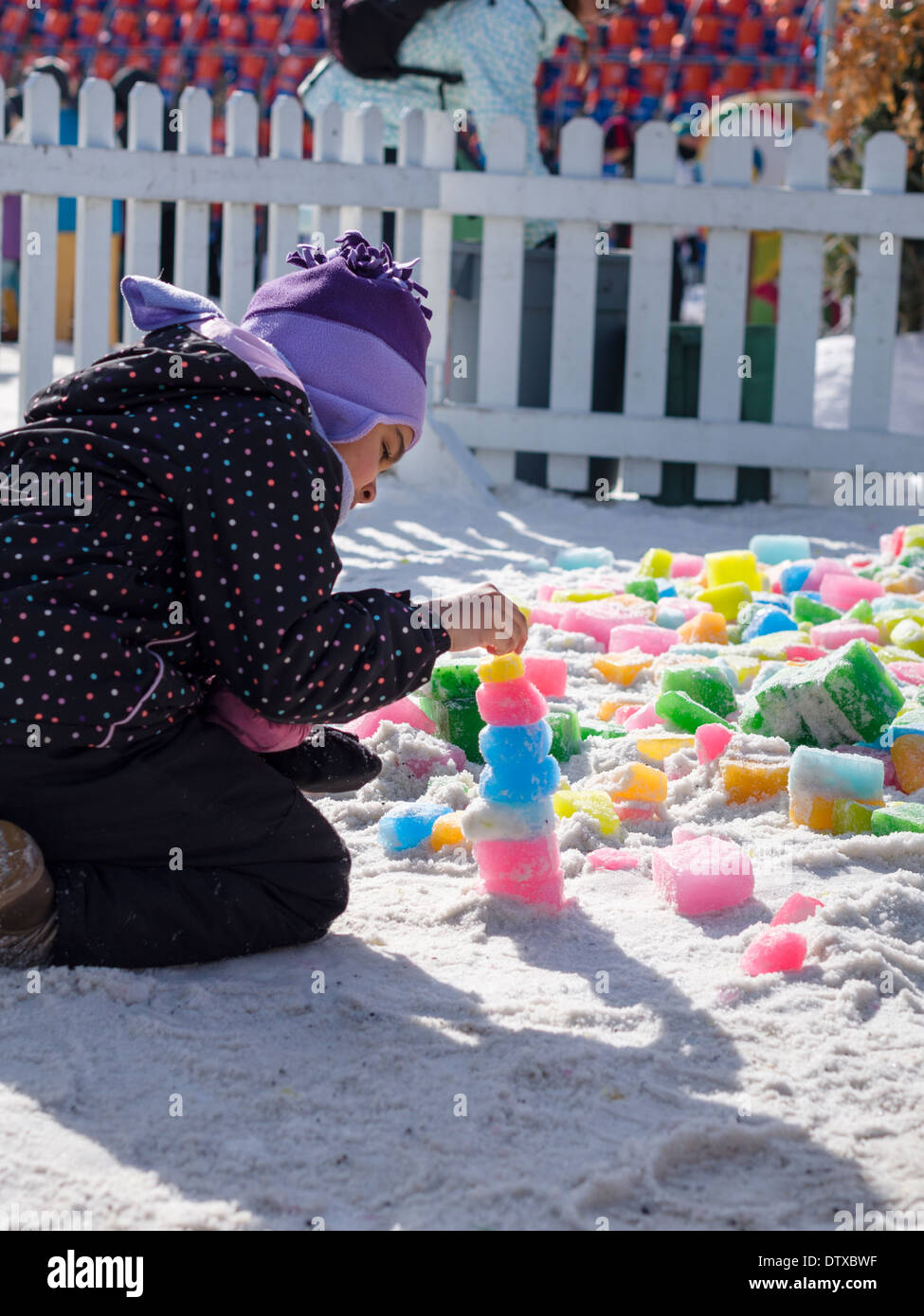 Coloured Ice Sculpture. A child uses coloured blocks of ice to build a ...