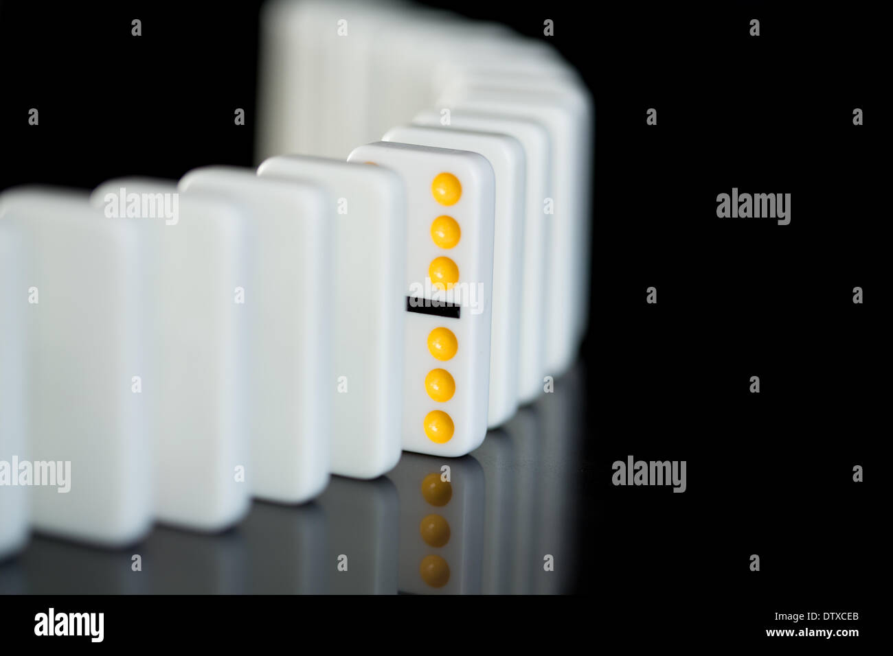 One yellow domino in a line of white ones Stock Photo - Alamy