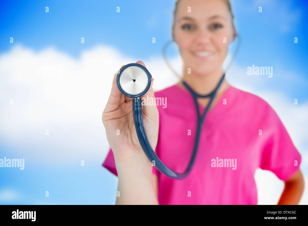 Happy nurse holding up stethoscope Stock Photo - Alamy