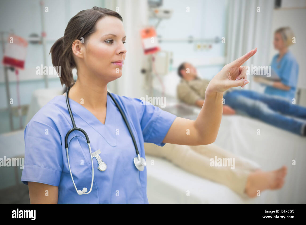 Nurse in hospital ward pointing to something Stock Photo - Alamy