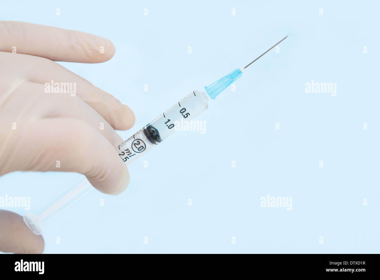 Gloved hand holding syringe Stock Photo - Alamy