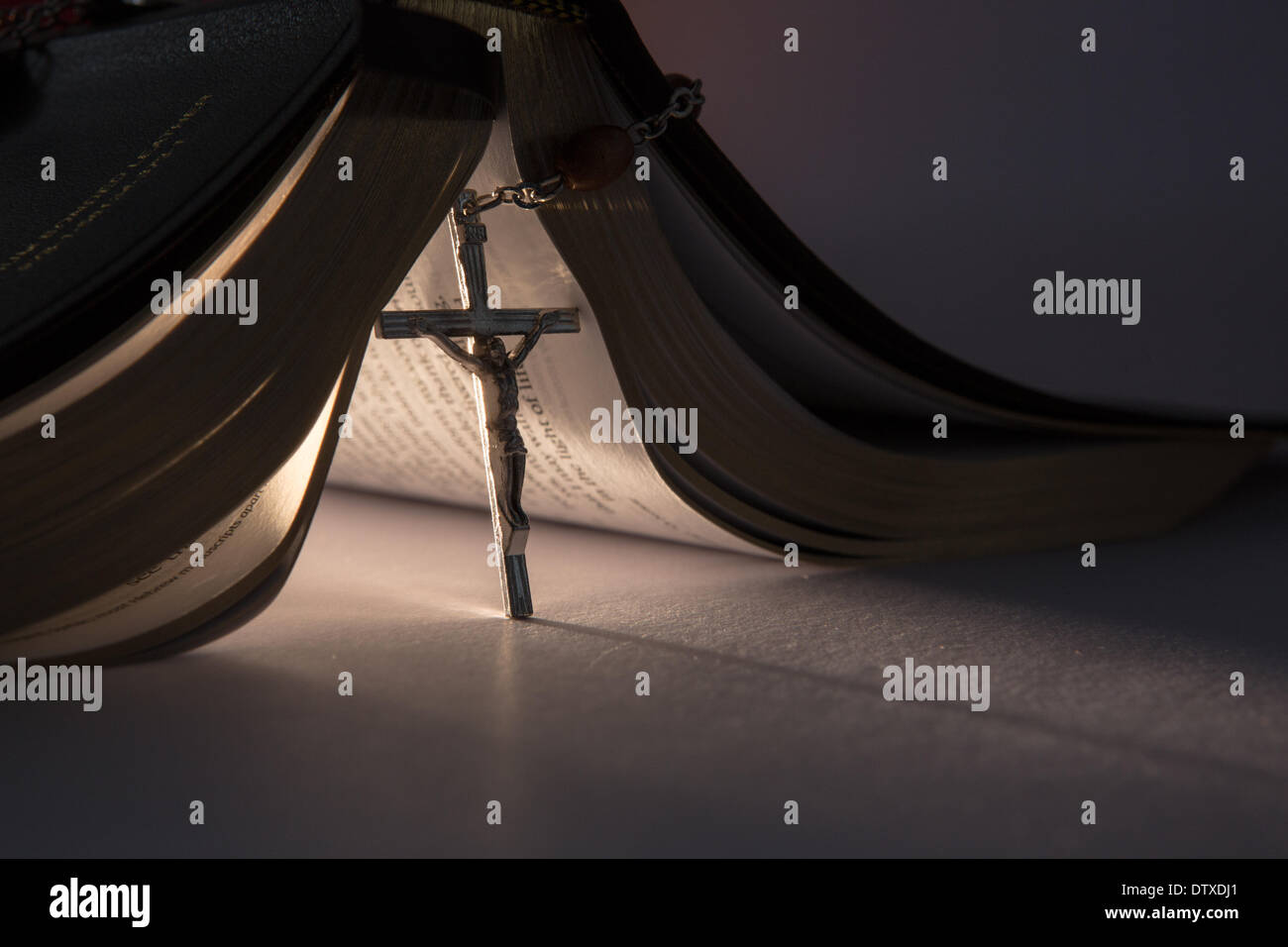 Crucifix propping open the bible Stock Photo - Alamy
