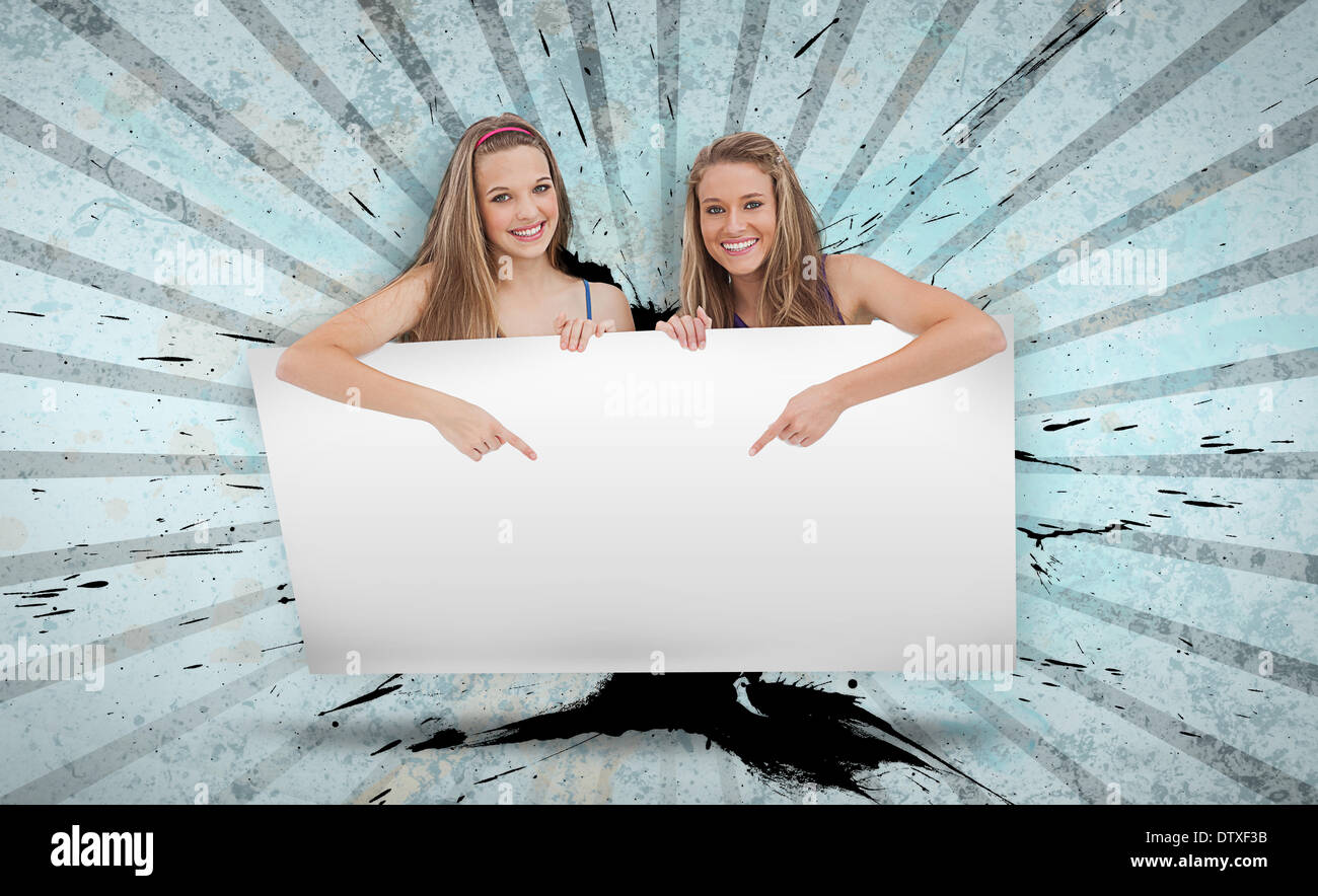 Pretty girls pointing to copy space card Stock Photo - Alamy