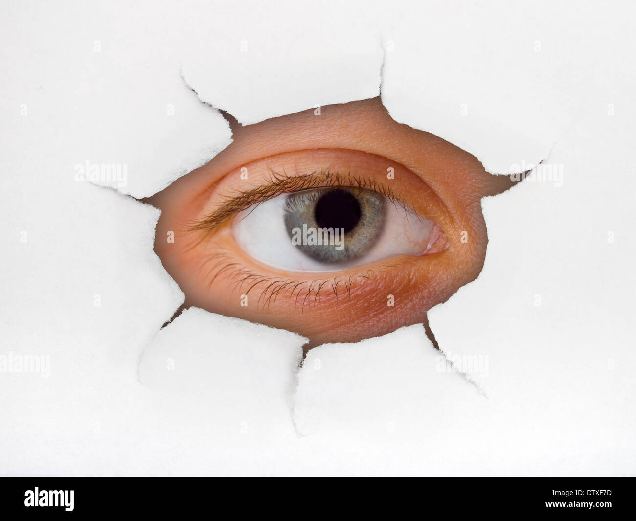 Eye looking through hole on paper Stock Photo - Alamy