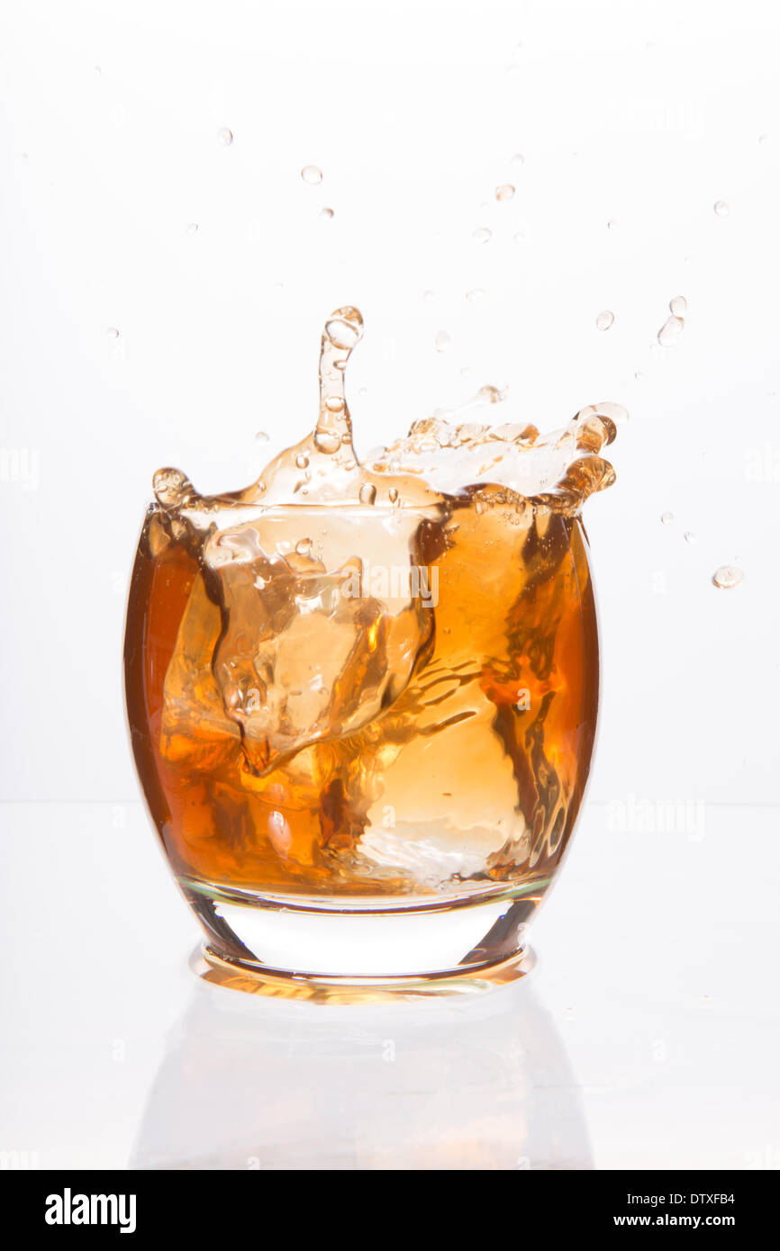 Tumbler glass with brown alcohol Stock Photo - Alamy