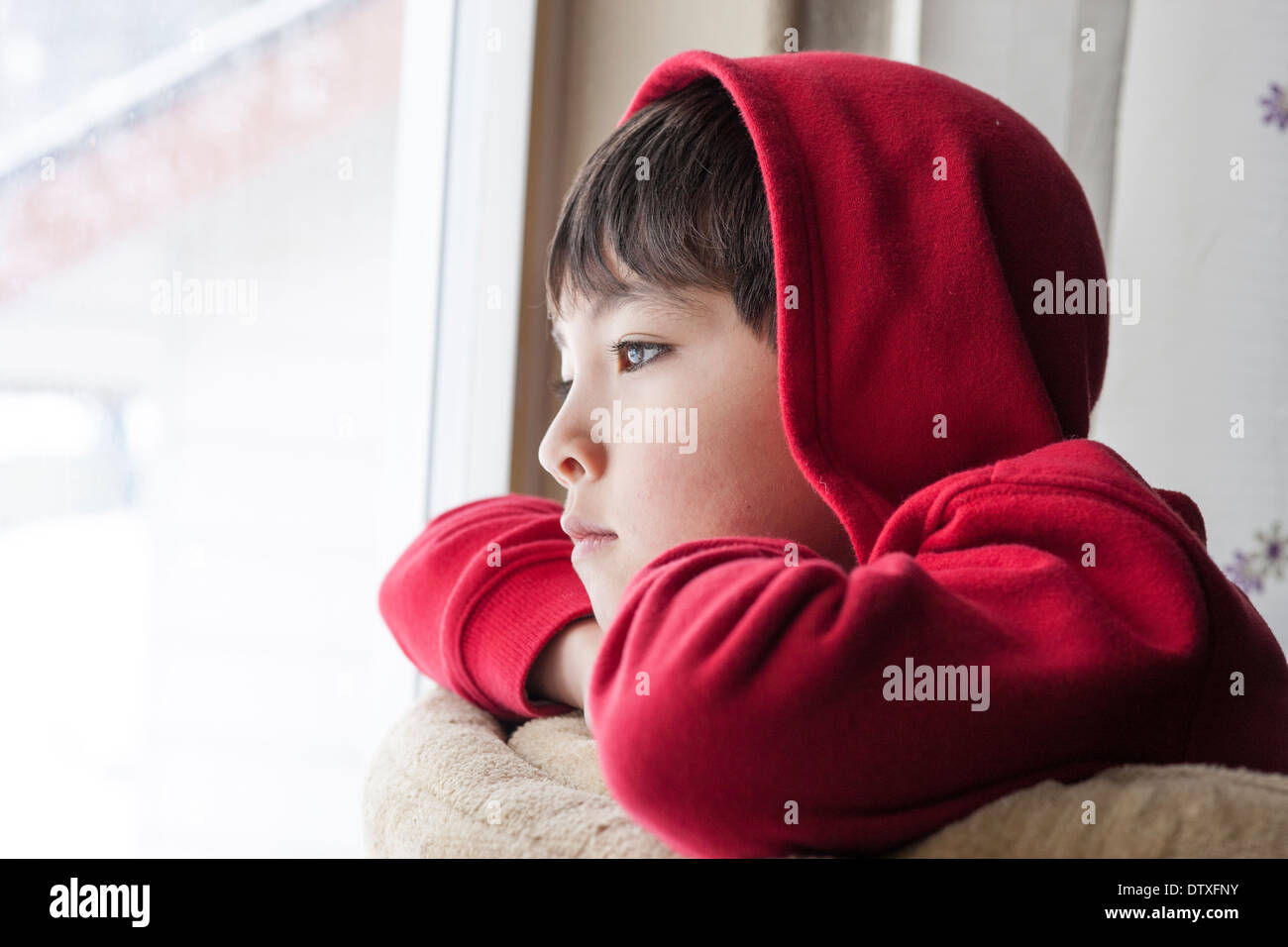 A young boy appears to be bored and stuck indoors Stock Photo - Alamy