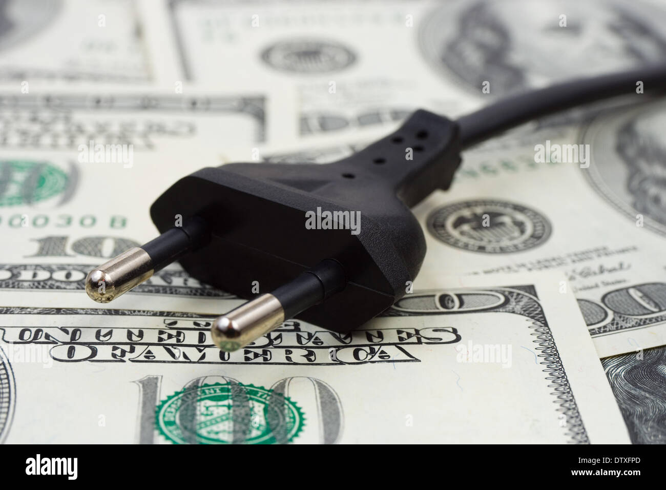 Electric plug on money background Stock Photo - Alamy