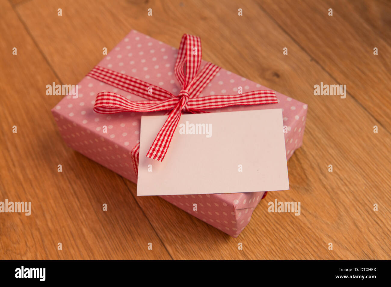 Pink wrapped present with blank card Stock Photo - Alamy