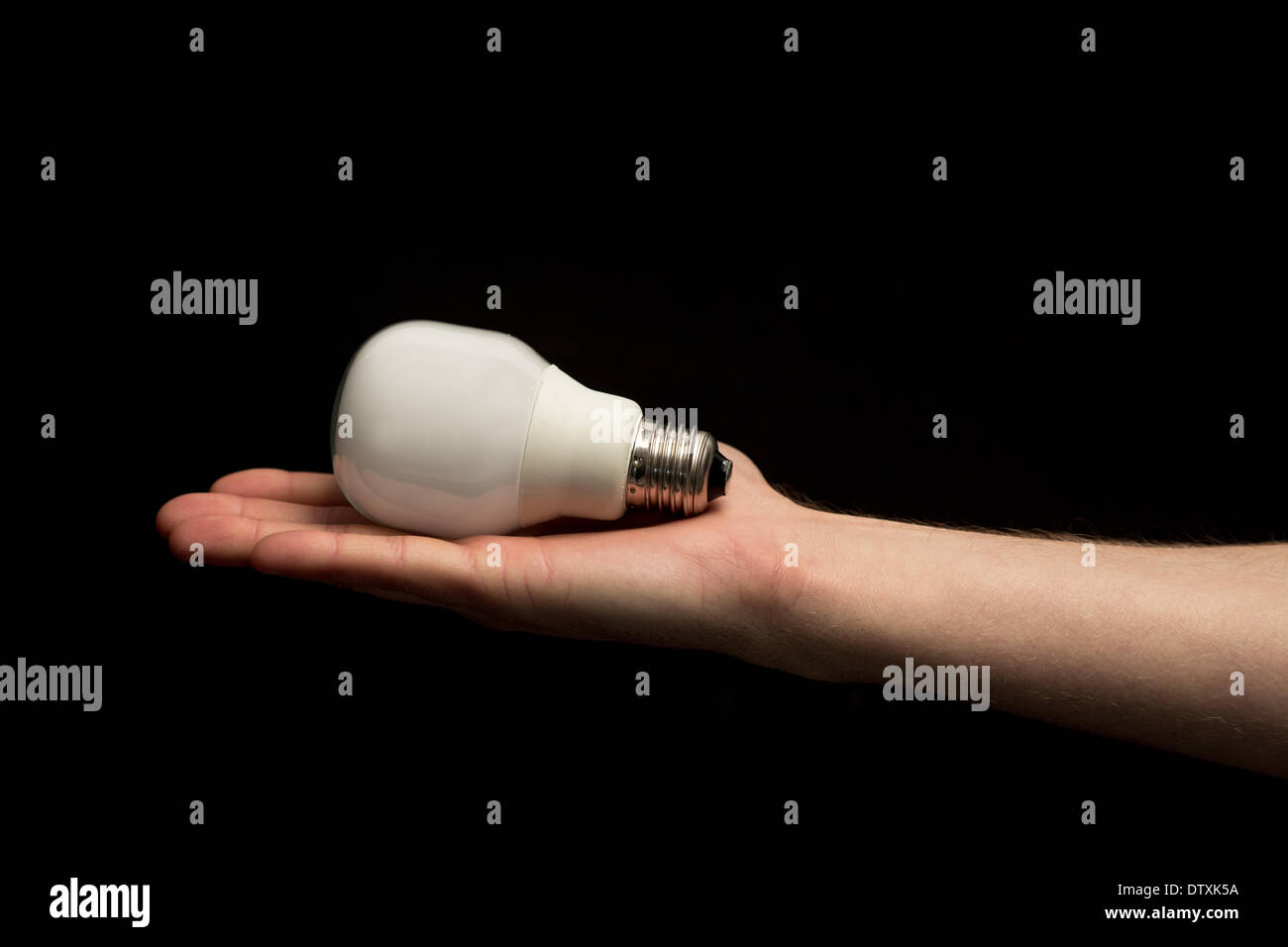 Hand holding economic light bulb Stock Photo - Alamy