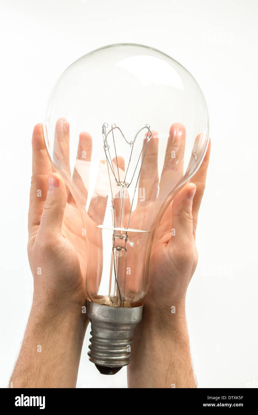Man holding big light bulb in his hands Stock Photo - Alamy