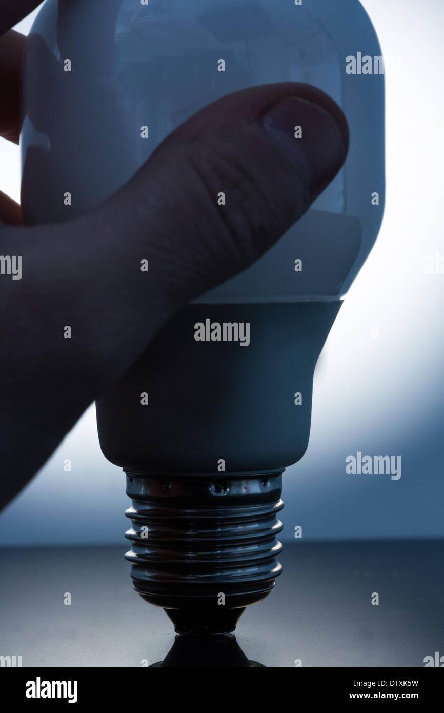 Hand holding an economic light bulb Stock Photo - Alamy