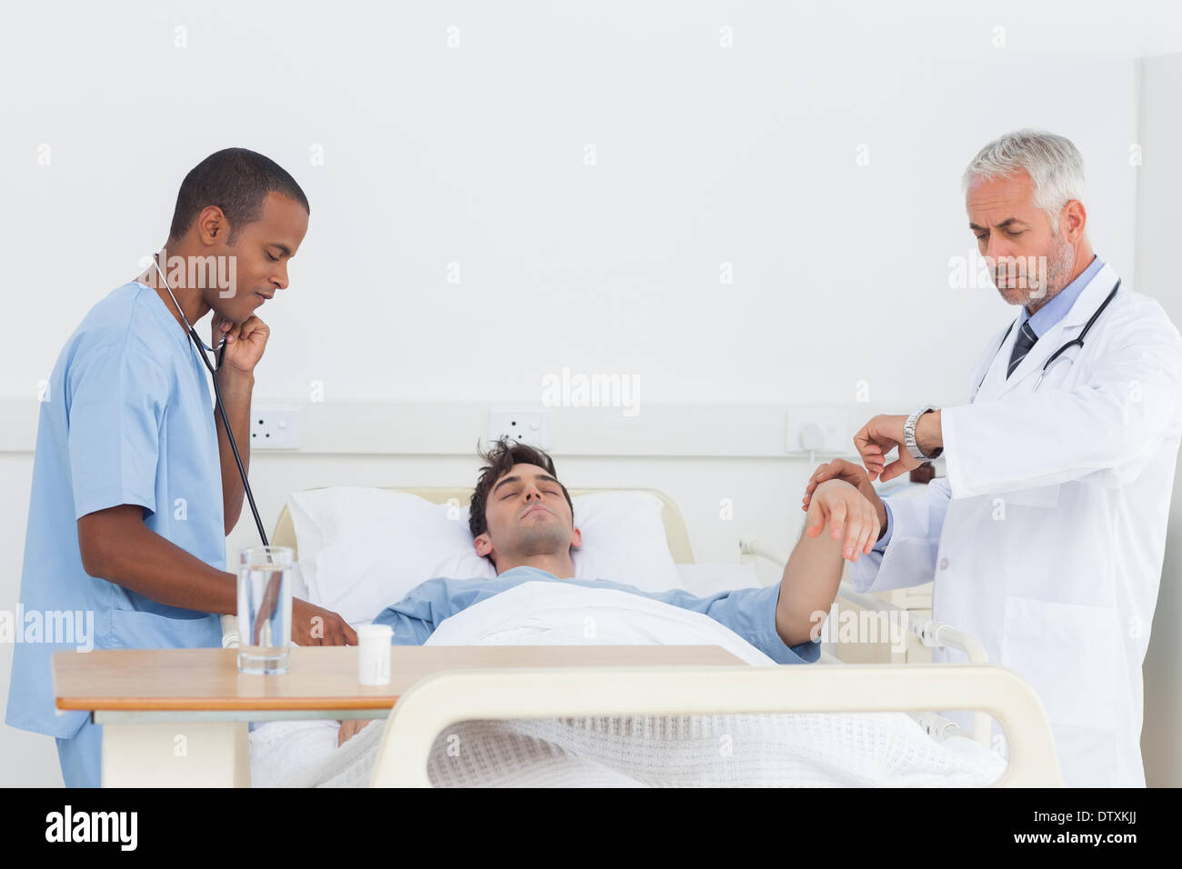 Doctors examining a patient Stock Photo - Alamy