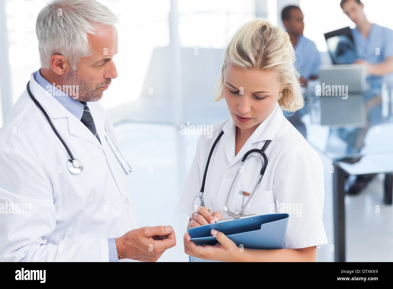 Two doctors holding a blue file Stock Photo - Alamy