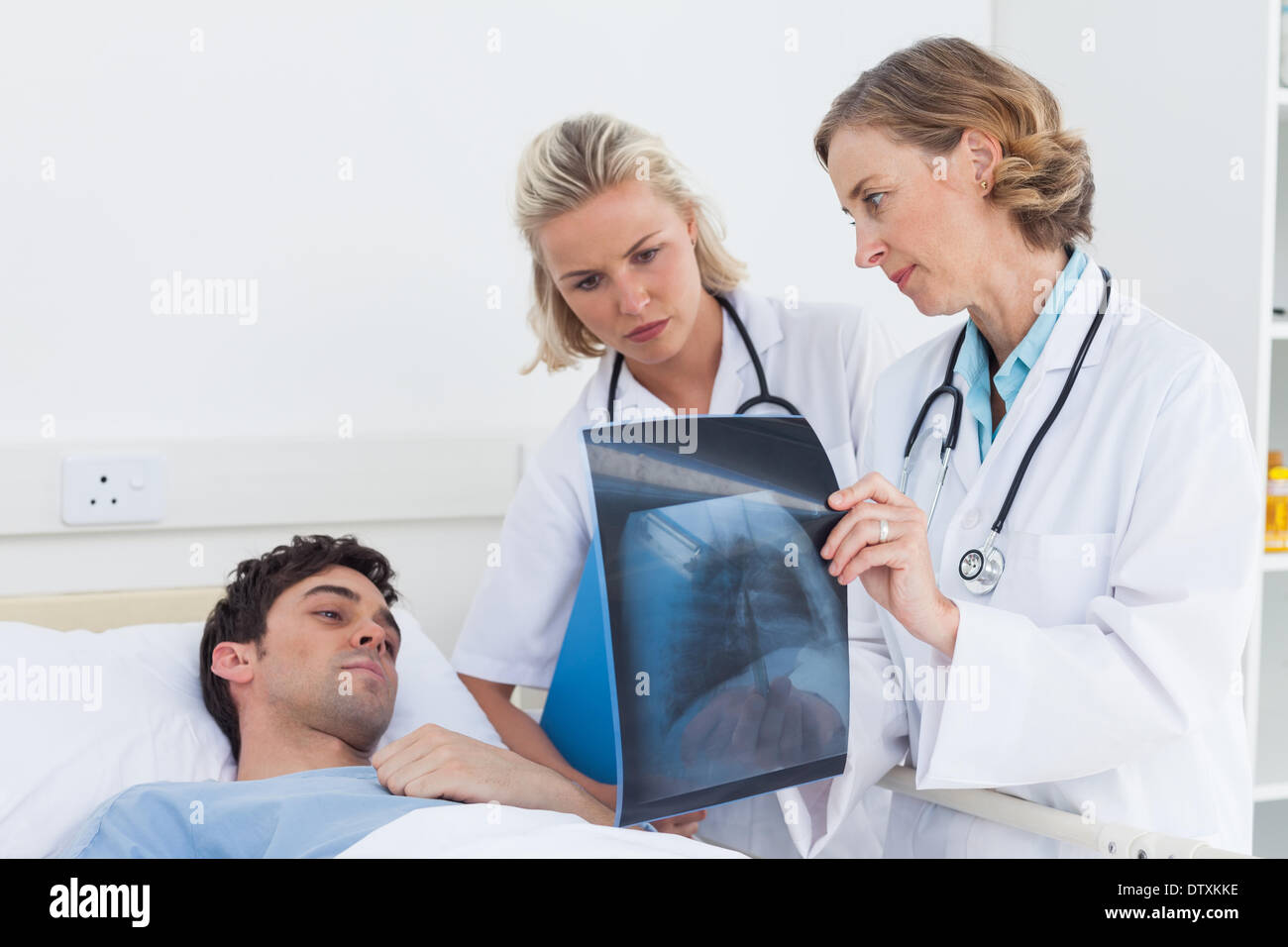 Doctors showing radiography to a patient Stock Photo - Alamy