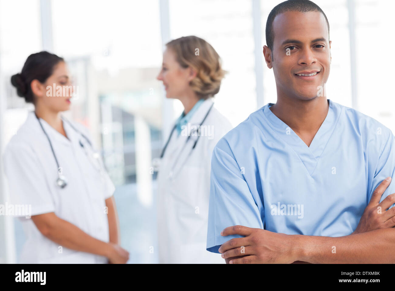 Attractive doctor with arms folded Stock Photo - Alamy