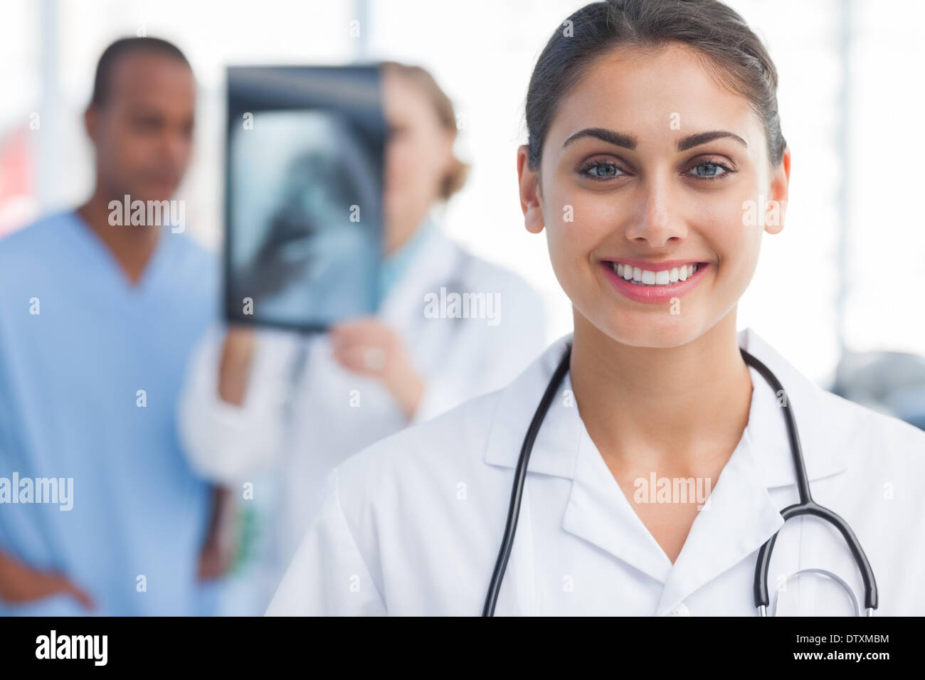 Smiling doctor standing in a bright hospital Stock Photo - Alamy