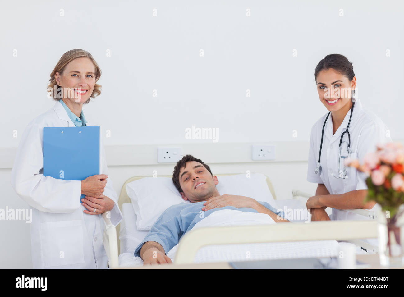 Doctors and patient looking at the camera Stock Photo - Alamy