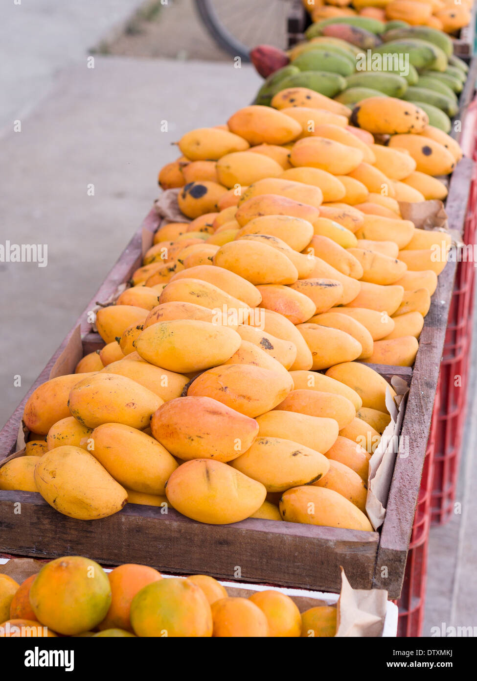 Yellow Mangoes on Sale. A display table in front of a produce shop with ...