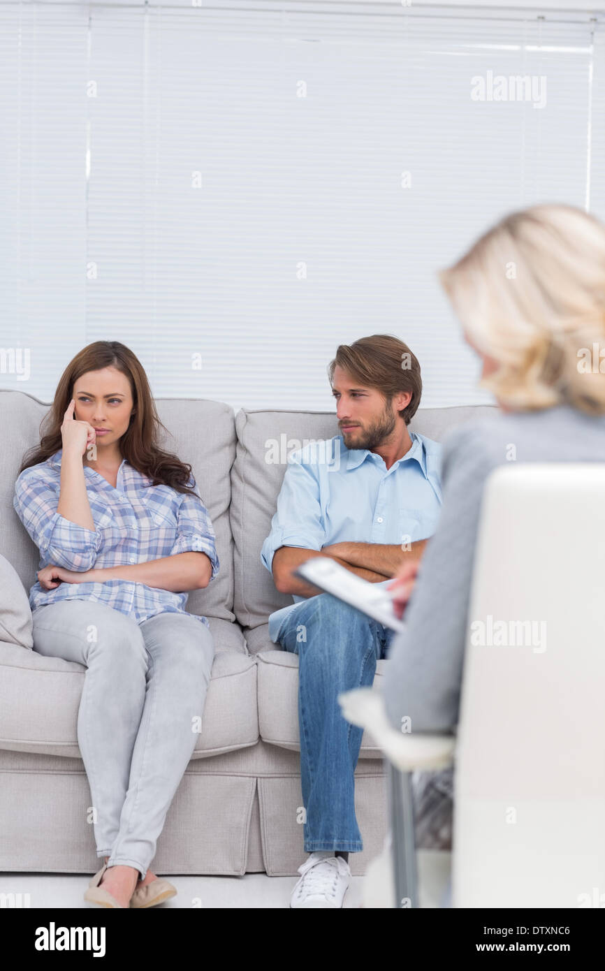 Troubled couple sit with arms folded Stock Photo - Alamy