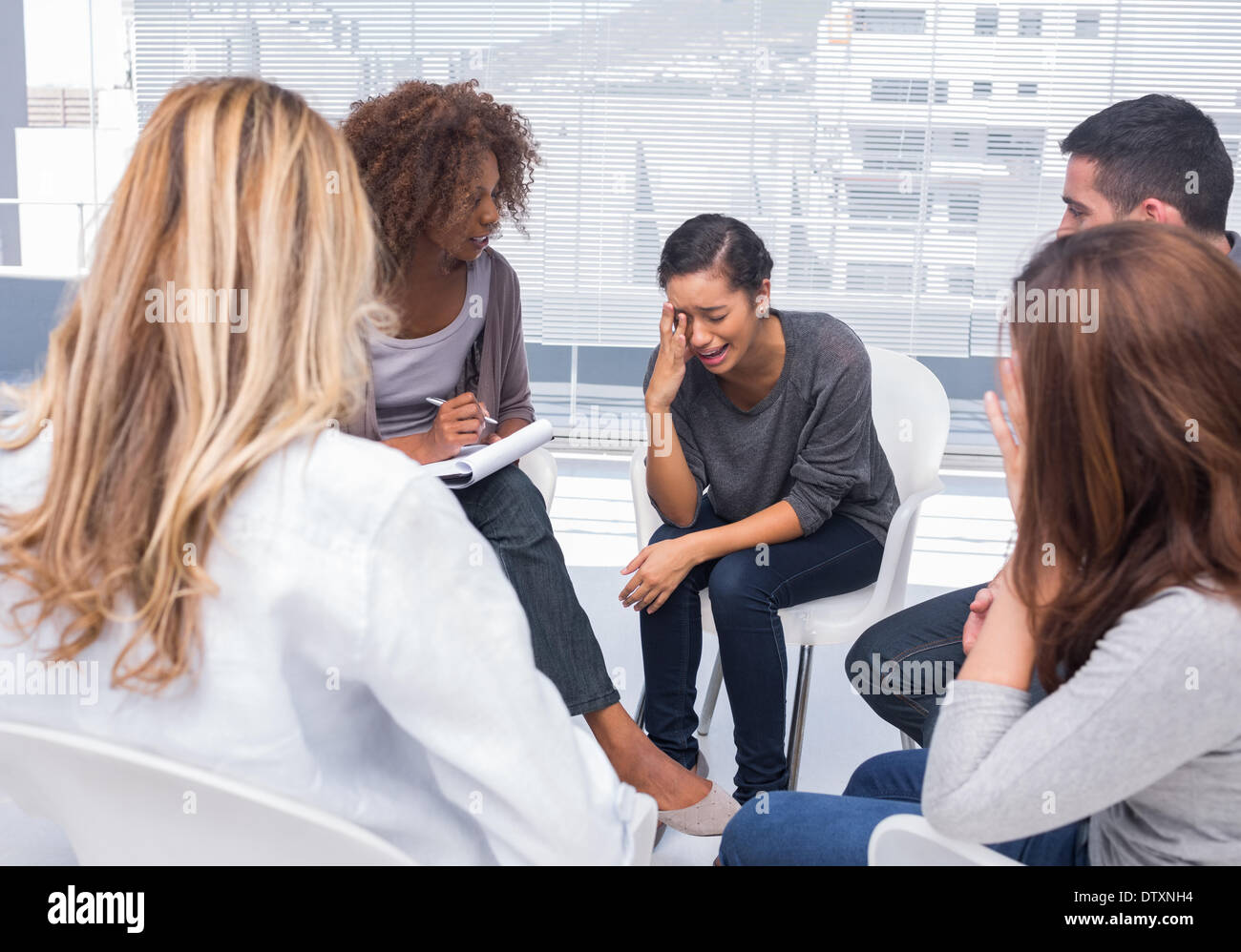 Woman getting distressed in group therapy Stock Photo - Alamy