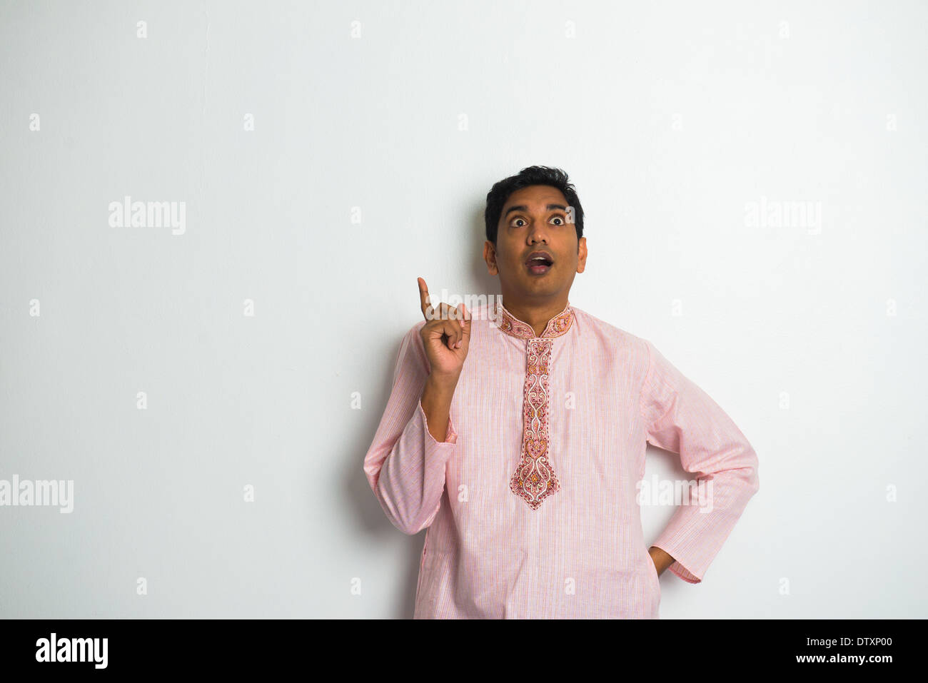 shocked indian male in traditional clothing and plain background Stock ...