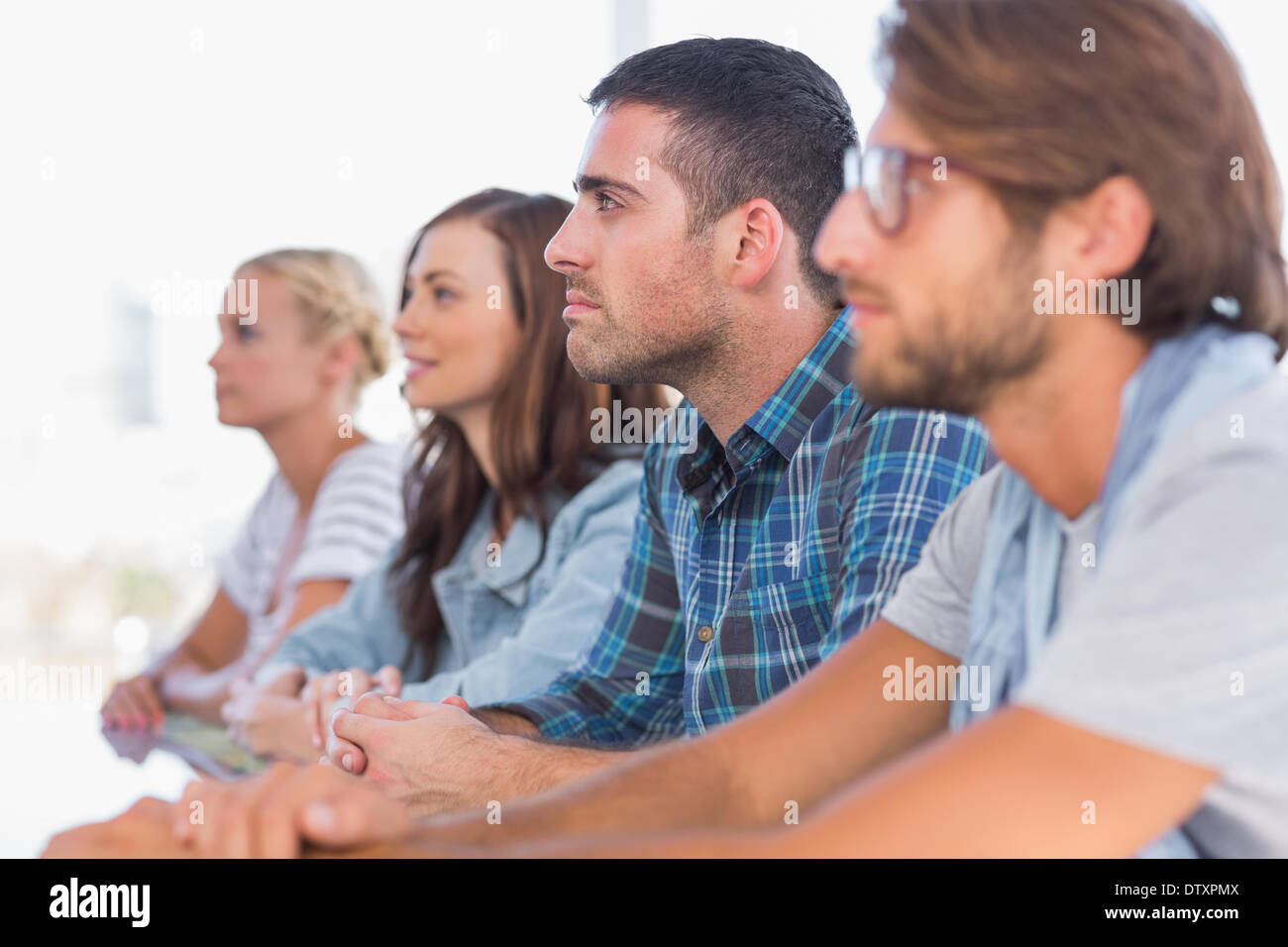 Creative team sitting in a line Stock Photo - Alamy