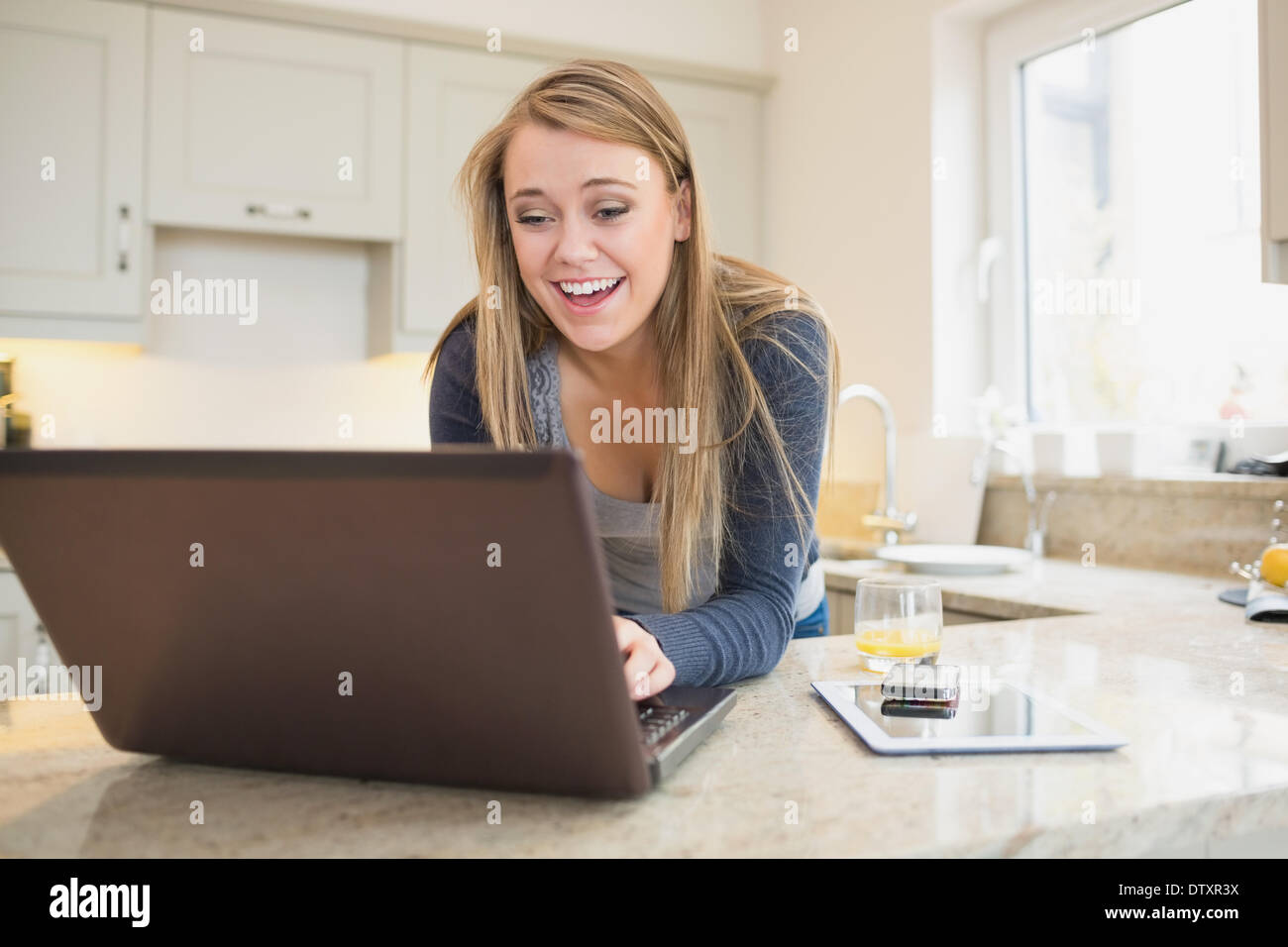 Woman laughing at laptop Stock Photo - Alamy