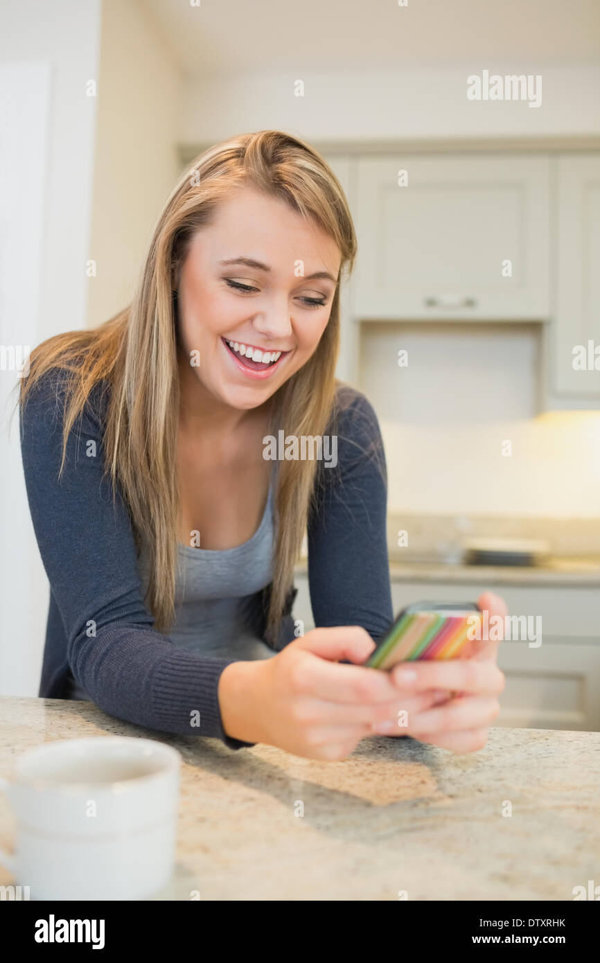 Woman texting in the kitchen Stock Photo - Alamy