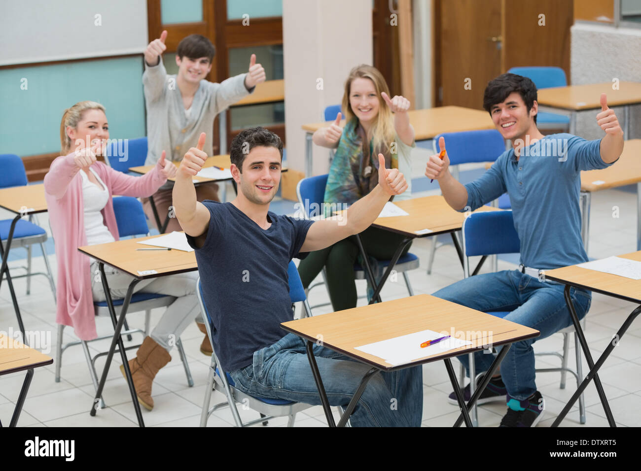 Students in classroom giving thumbs up Stock Photo - Alamy