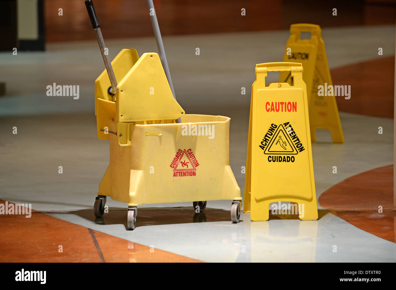 Janitorial mop and caution sign on hallway Stock Photo - Alamy