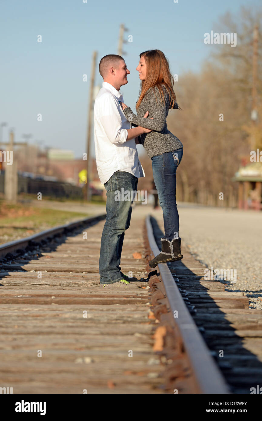 Young couple showing affection on railroad tracks Stock Photo - Alamy