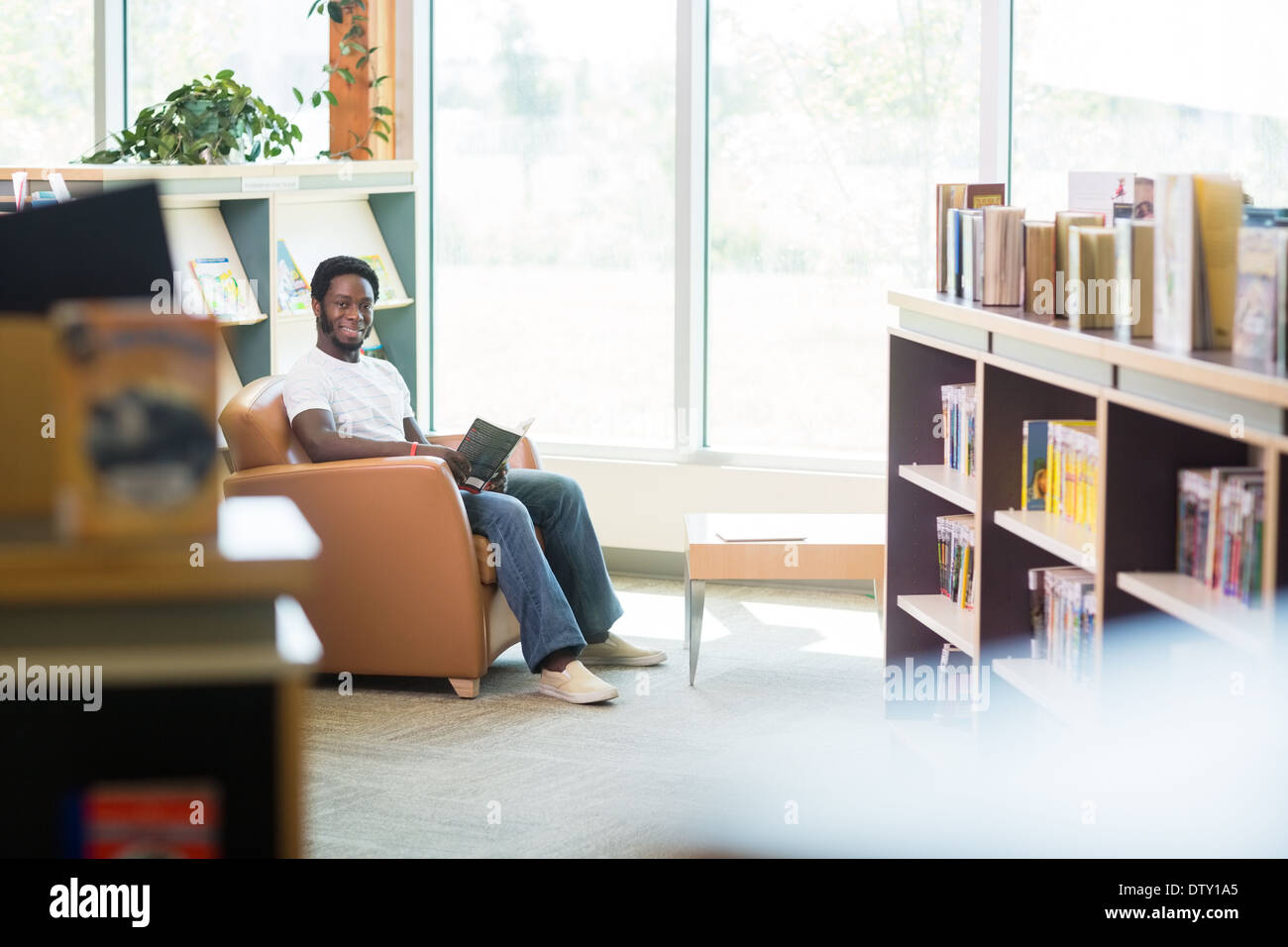Young man reading full length sit hi-res stock photography and images ...